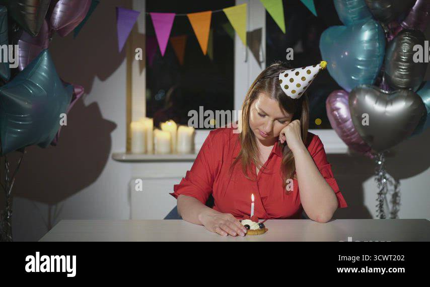 Young woman celebrating her birthday alone. Sad bored and tired girl ...