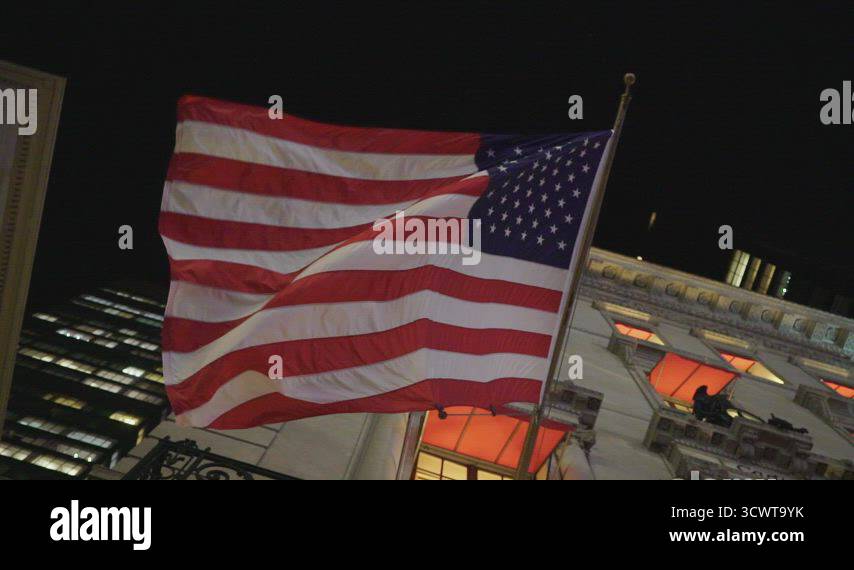 American USA flag at night. Street of New York city Stock Video Footage ...