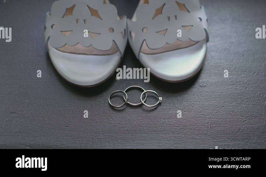 Wedding rings and bridal shoes. Pair of marriage symbols. Love of bride ...