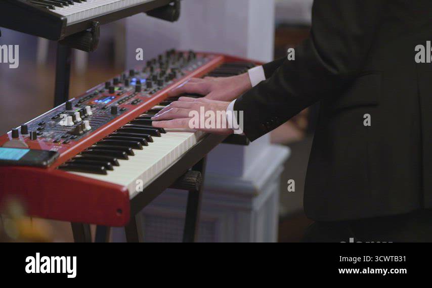 Musician playing electronic keyboard synthesizer piano. Band at concert ...