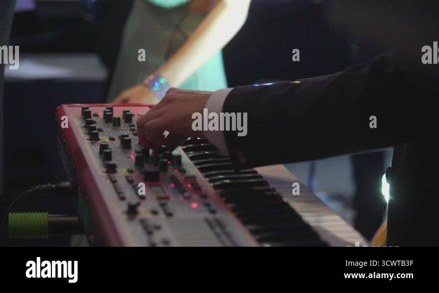 Musician playing electronic keyboard synthesizer piano. Band at concert ...