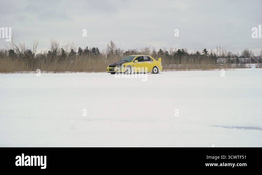 Car drives by icy track on snow covered lake at winter. Sport car ...