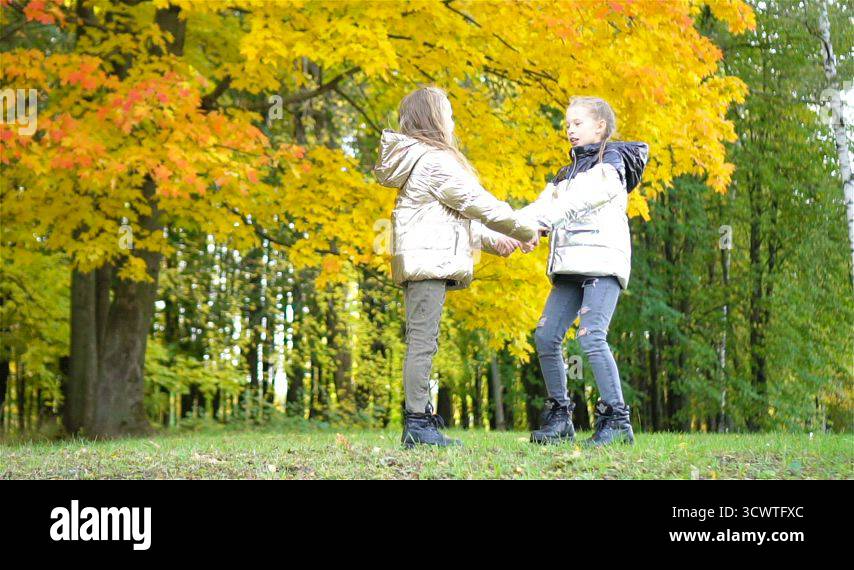 Little adorable girls at warm day in autumn park outdoors Stock Video ...