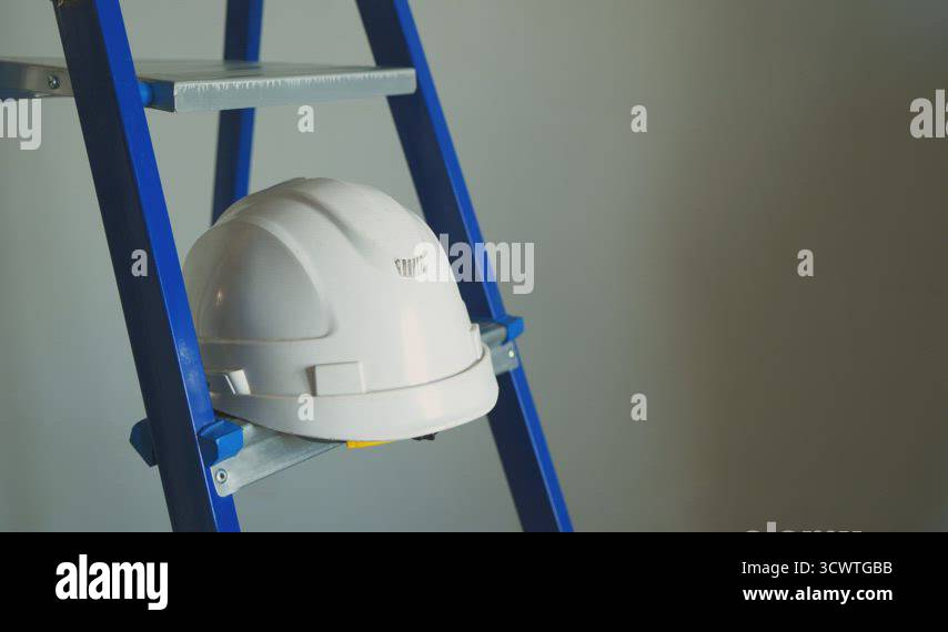White helmet and blue metal ladder in aparment construction site Stock ...