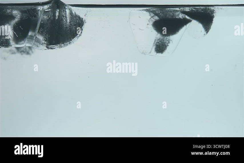 Clear ice cubes float in blue water close up Stock Video Footage - Alamy