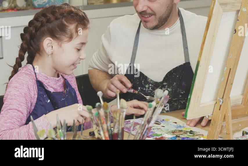 Cropped shot of a cute little girl smiling talking to her dad mixing ...