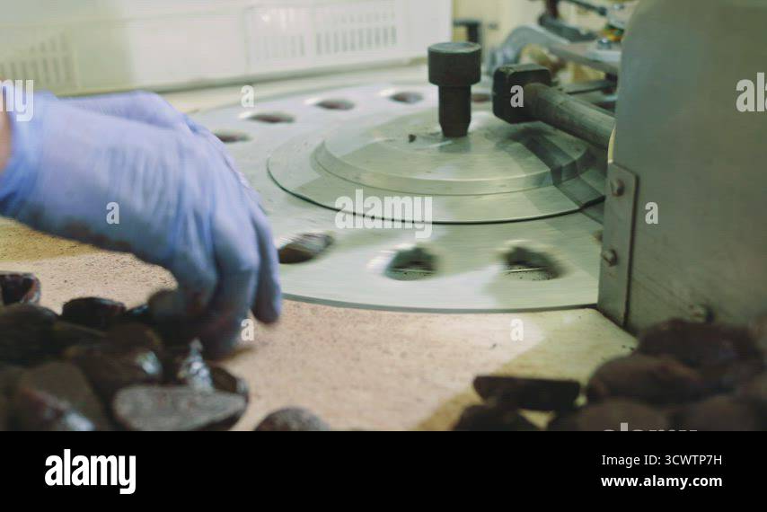 Crop hands putting sweets into wrapping machine. Candy factory Stock ...