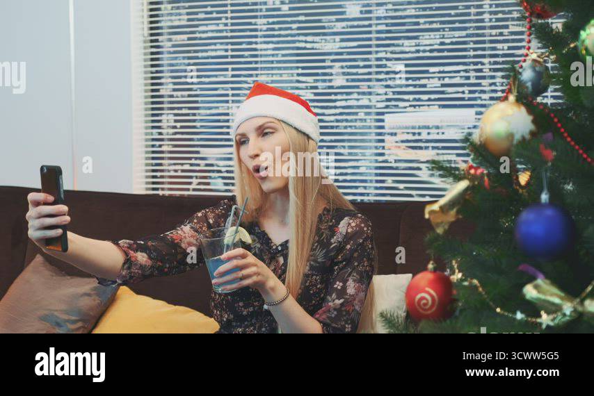 Side view of good-looking woman making selfie in Santa hat and with ...