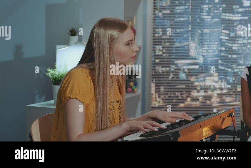 Vocalist blonde singing a song and playing the keyboard during ...