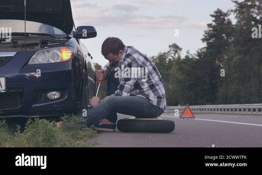 Guy changing a tire outdoors Stock Video Footage - Alamy