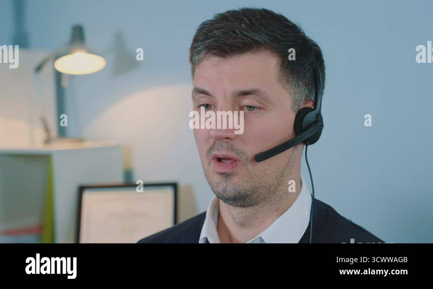 Close-up of caucasian call center agent talking in headset on phone ...