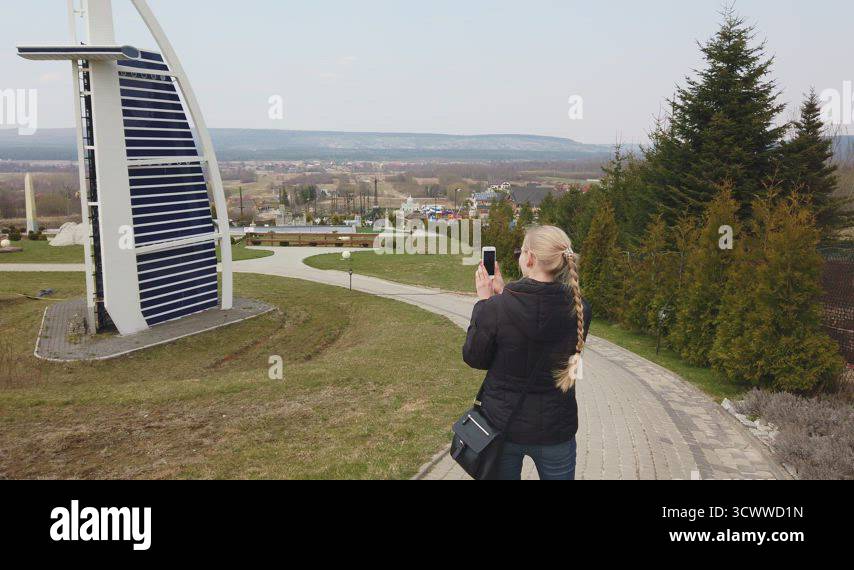 Female makes photo walking on foot near a miniature model of the Burj ...