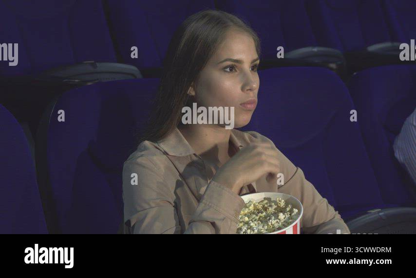 The girl shows a sign of silence sitting in the cinema hall Stock Video ...