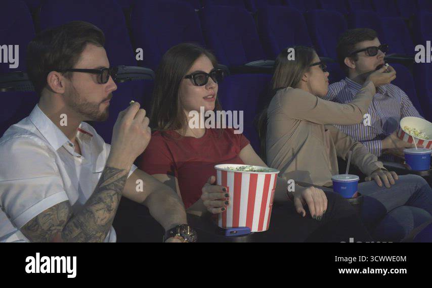 Two couples sit in the cinema and eat popcorn Stock Video Footage - Alamy