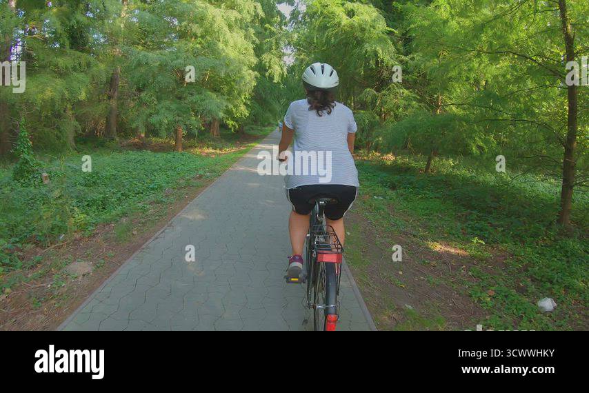 Pretty woman biking on the bike road in Hungary, near a village Heviz ...