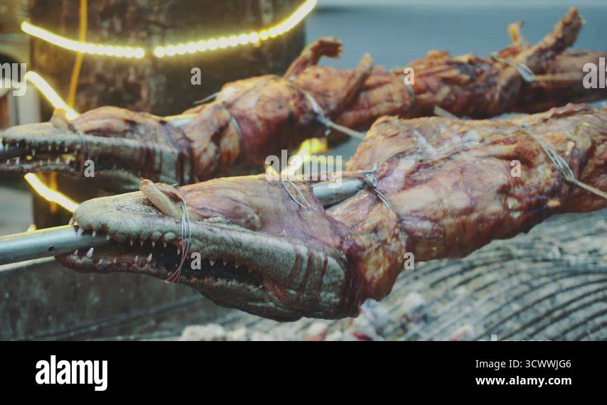Grilled crocodile on the open fire at sea food restaurant, exotic meals ...