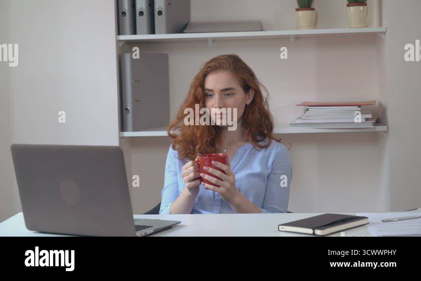 ginger girl drink tea at work Stock Video Footage - Alamy