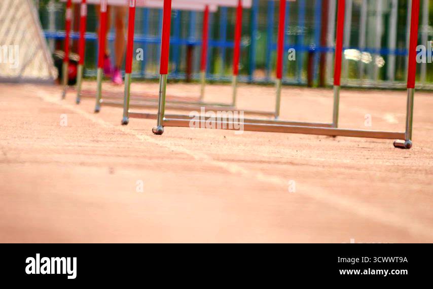 Hurdle race training track, woman athlete runs and jumps over hurdles ...