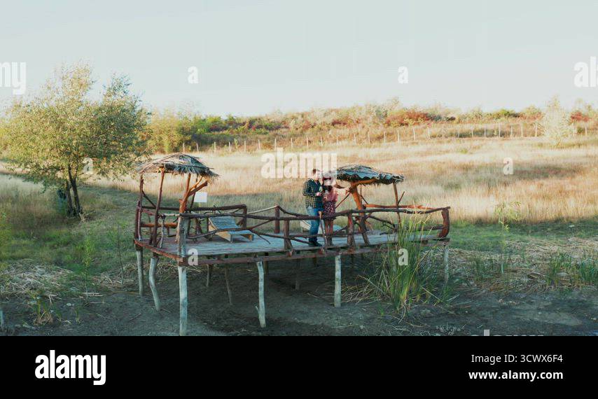 Couple enjoying a glass of wine on a pontoon in a rural are Stock Video ...