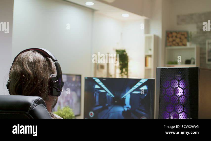 Over shoulder shot of man with long hair playing shooter games Stock ...