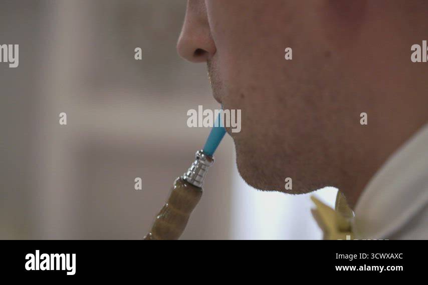 Man at the party having fun and Smoking hookah. Celebrating a wedding ...