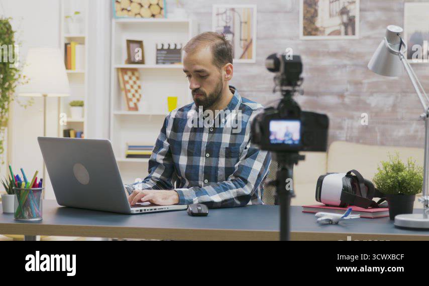 Famous young vlogger typing on laptop while talking Stock Video Footage ...