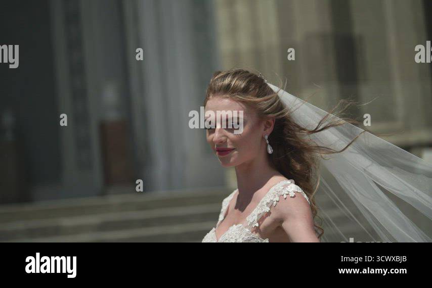 Young bride posing in a city. Waving veil at windy summer day Stock ...
