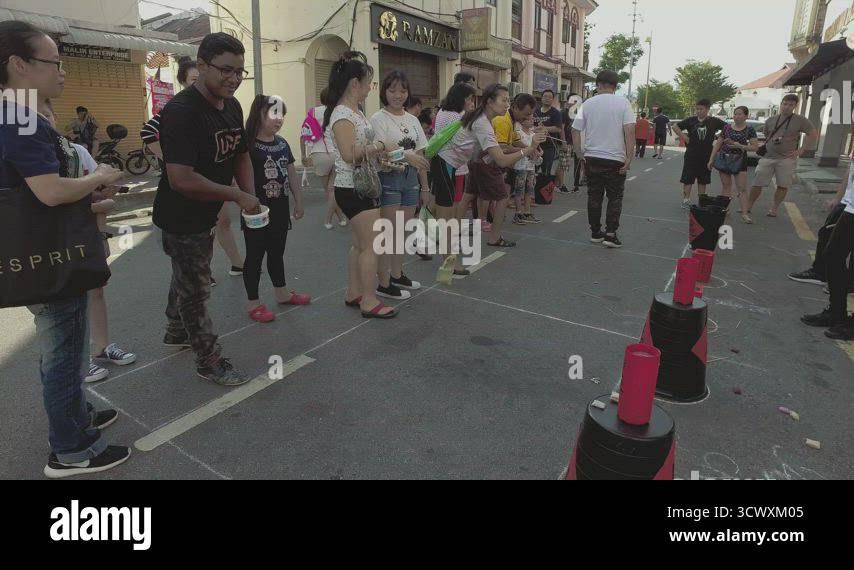 People play traditional game in front of booth during chinese new year ...