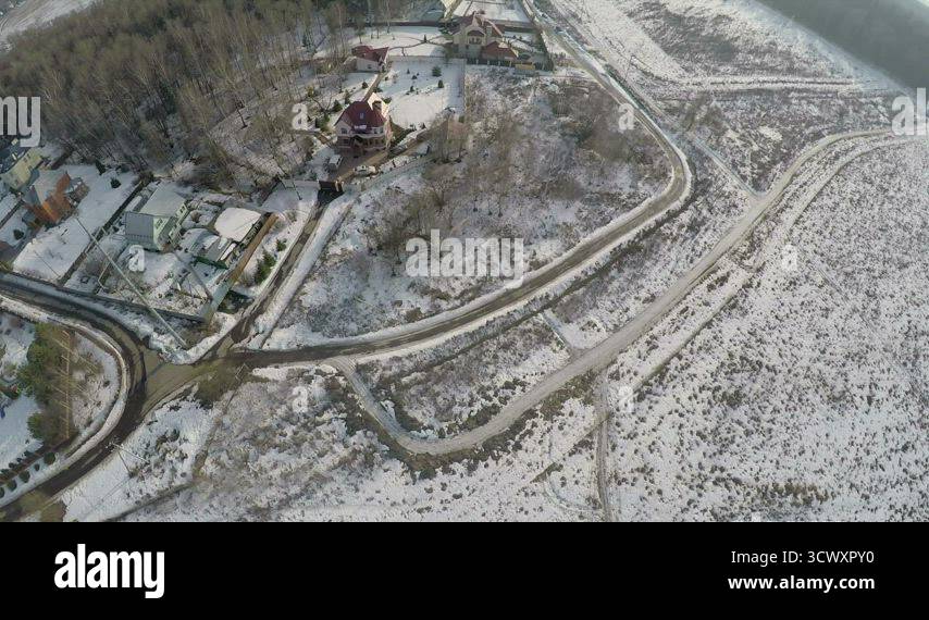 Winter countryside scene with houses, forest and snowy fields Aerial ...