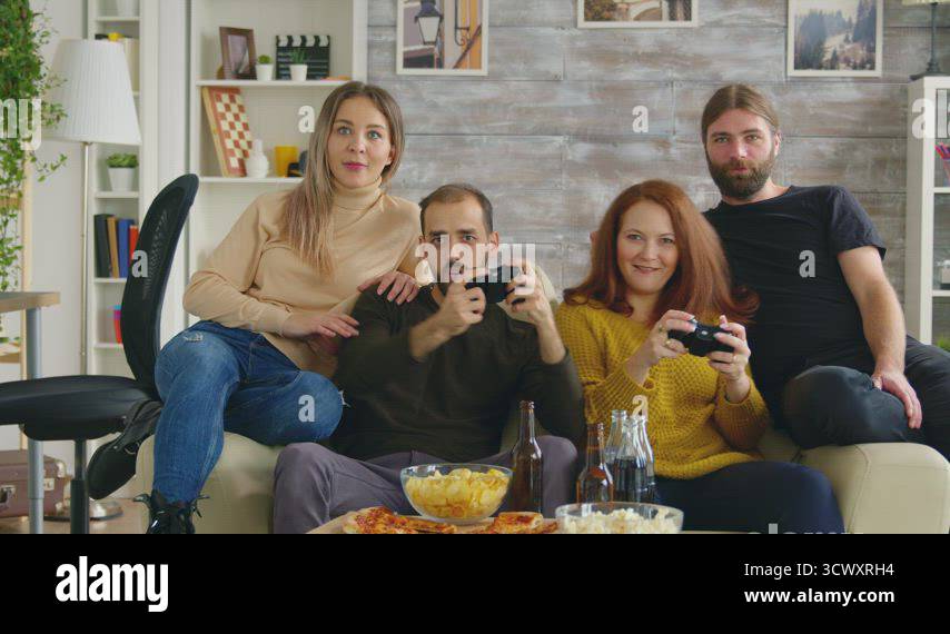 Excited man playing video games and trying to make her friend lose ...