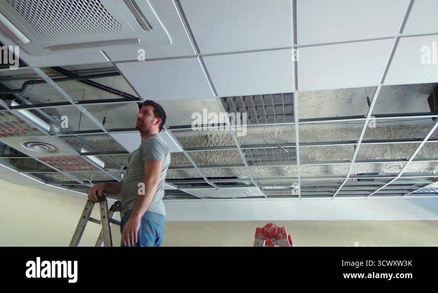 Construction worker performs a suspended ceiling maintenance Stock ...
