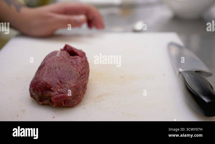 Close up of male cook hands seasoning a piece of raw beef meat Stock ...