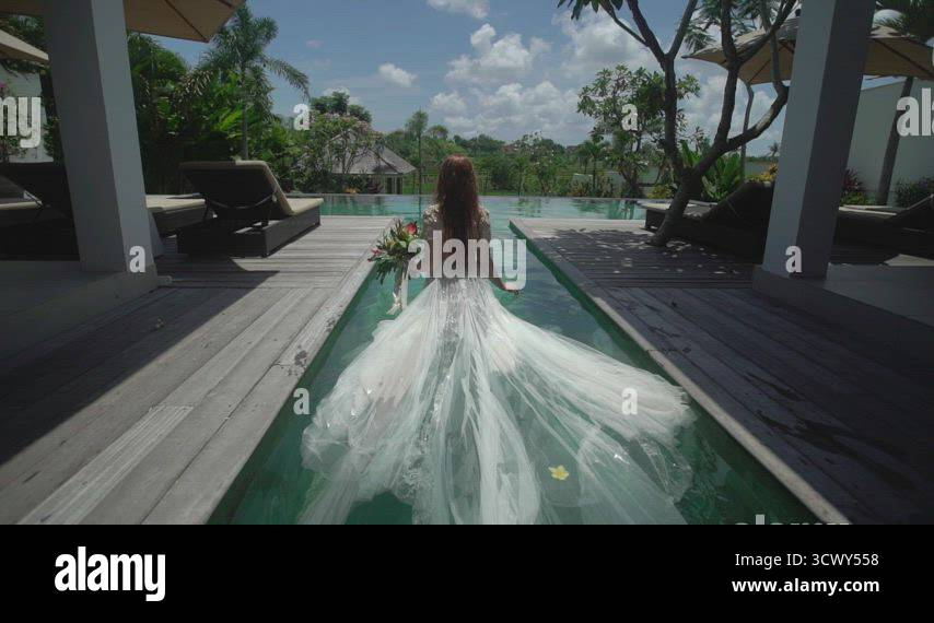 Bride in wedding dress comes to the pool Stock Video Footage - Alamy