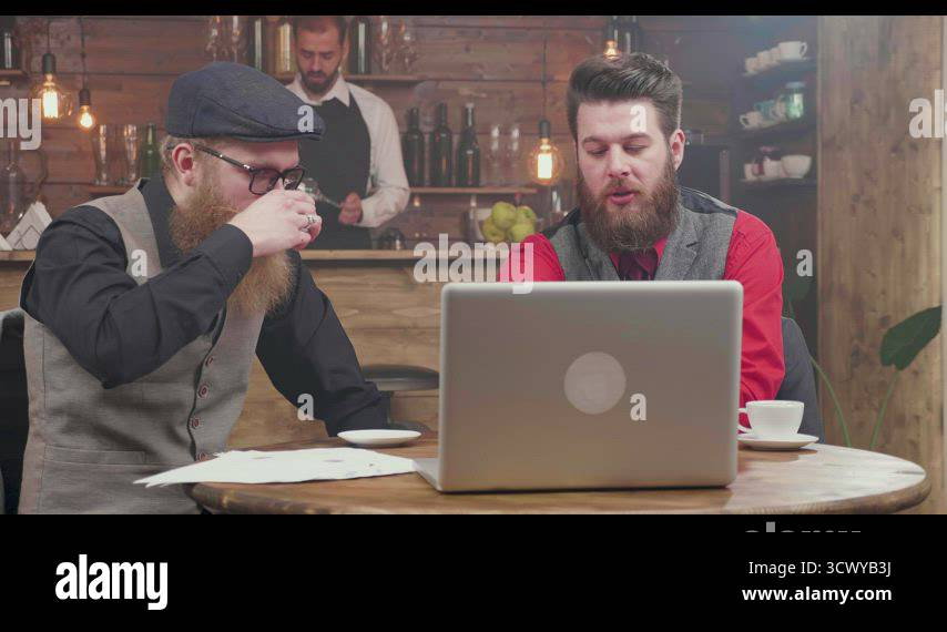 Men in stylish suits and with nice beards are having a video conference ...