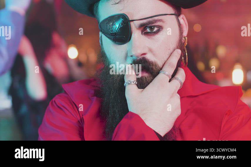 Portrait of a young man dressed in pirate costume with an evil look and ...