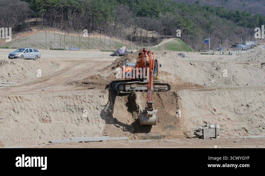Orange backhoe moving dirt Stock Video Footage - Alamy
