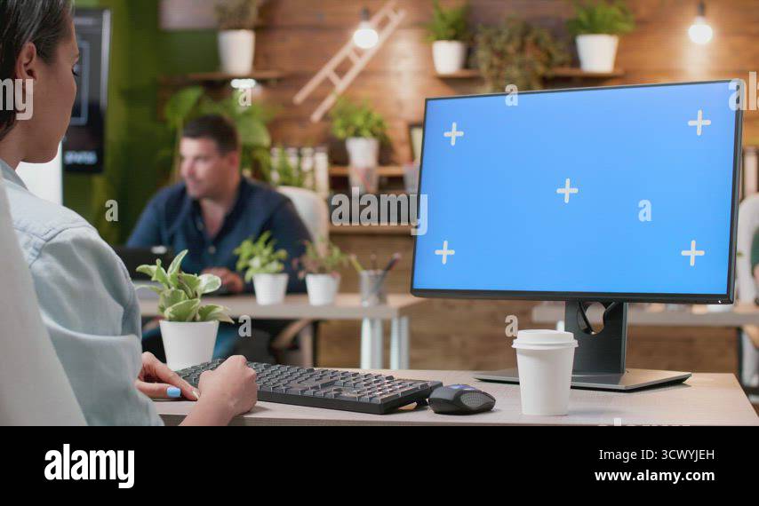 Woman typing on a computer with a blue screen mock-up Stock Video ...