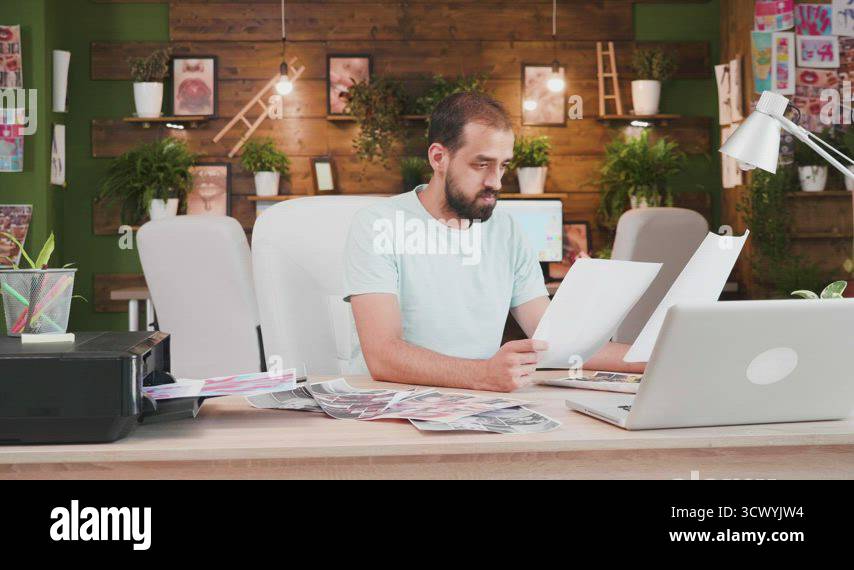 Focused creative art director looking through his ideas sitting at the ...