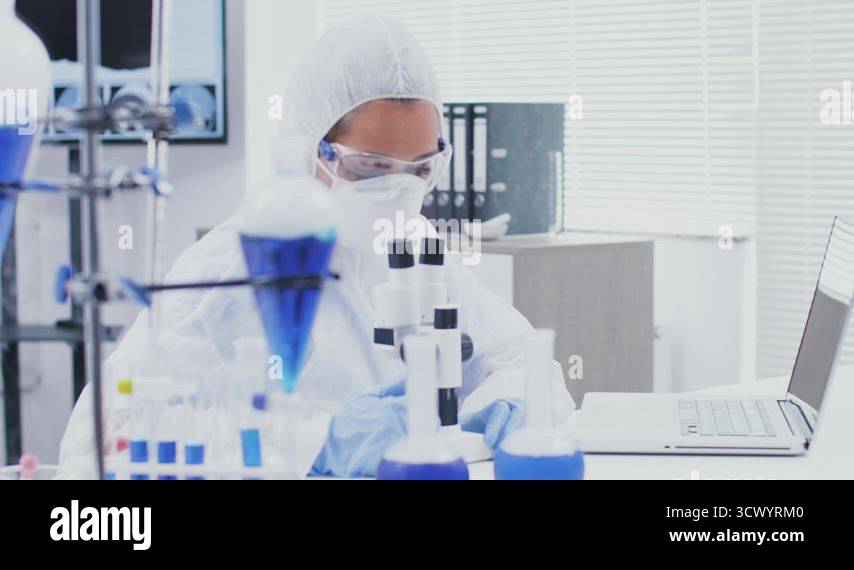 Female scientist typing formula on laptop and looking through ...
