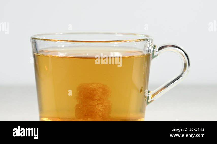 Throwing brown sugar cubes in cup of green tea Stock Video Footage - Alamy