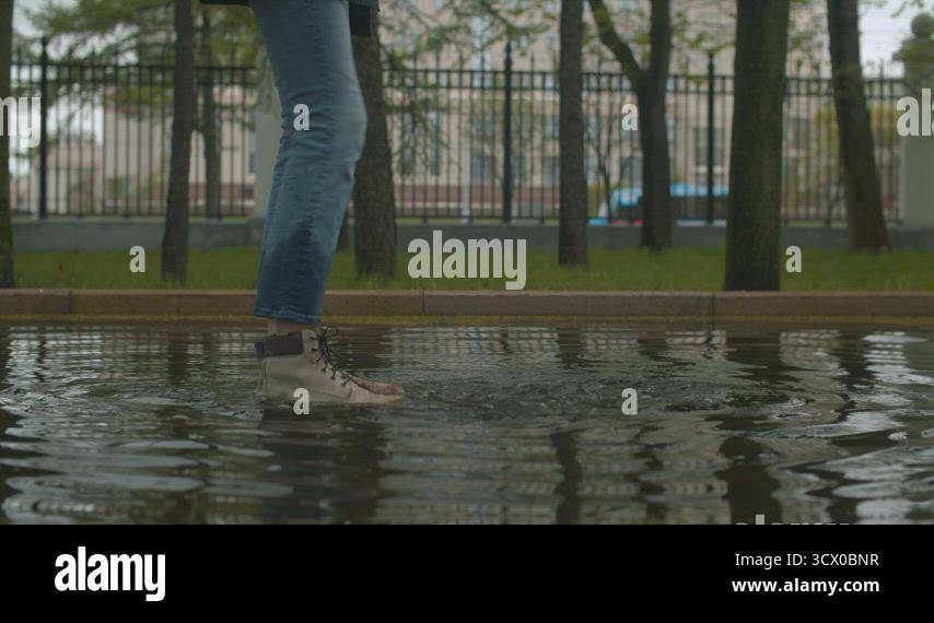 Legs of woman walking in a puddle Stock Video Footage - Alamy