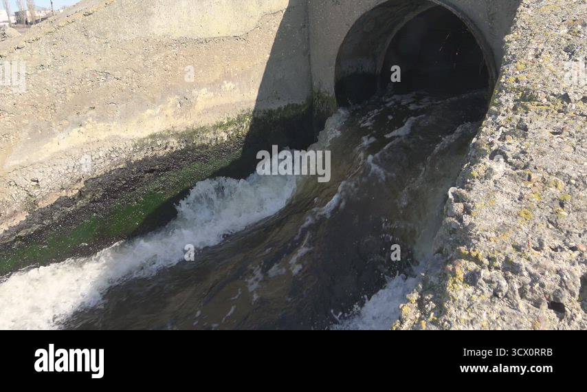Water pollution. Dirty water from treatment plants flows through a pipe ...