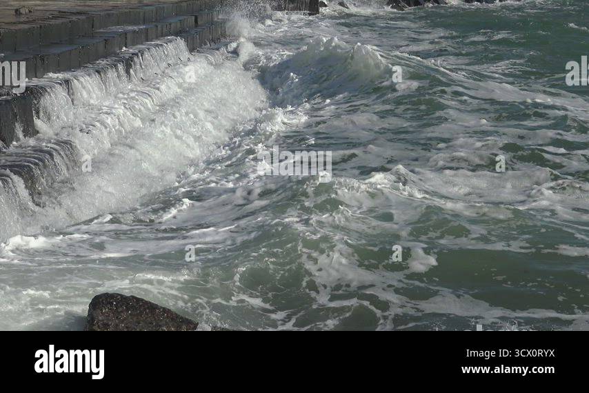 Storm at sea. Big waves are breaking on concrete shore protection ...