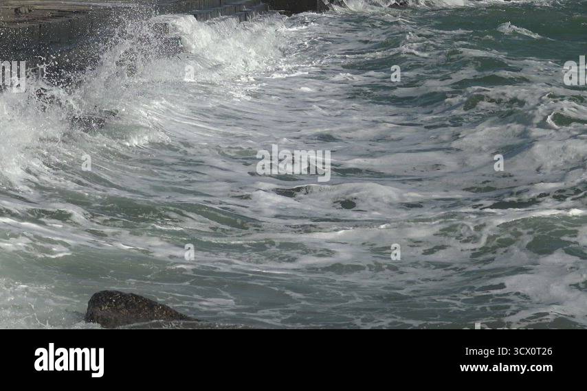 Storm at sea. Big waves are breaking on concrete shore protection ...