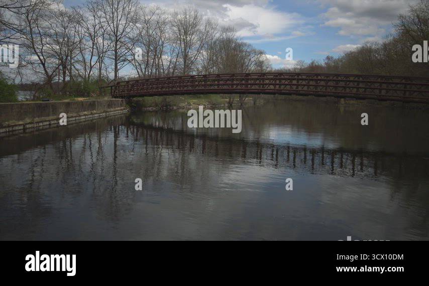 Metal bridge over the canal, reflection of the bridge in the water ...