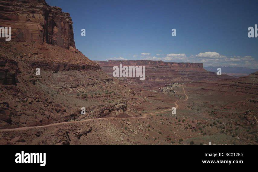 Mountain road among the landscape of red erosion rocks in Canyonlands ...
