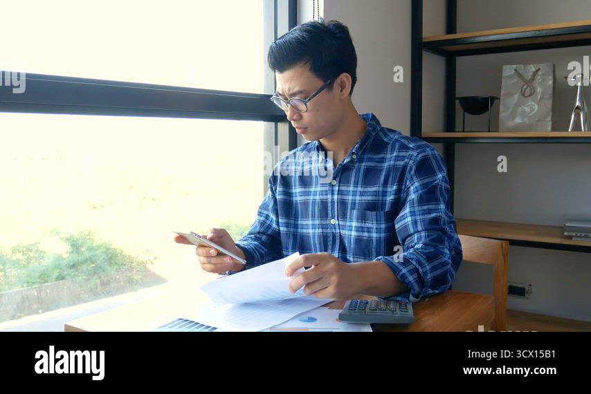 footage, serious Asian business man working with paper work and ...