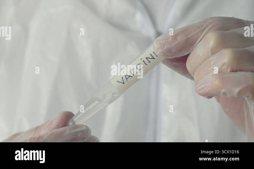 Virologist holding tube with vaccine inscription in scientific ...