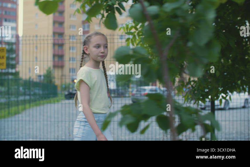Teenager girl with two braids walking on residential area in modern ...