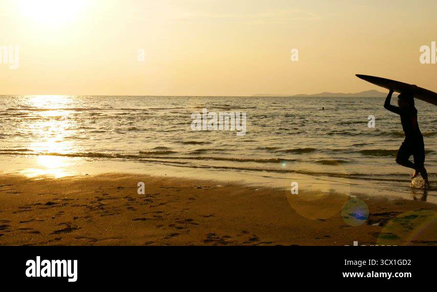 silhouette of young happy surf man running with long surf boards at ...